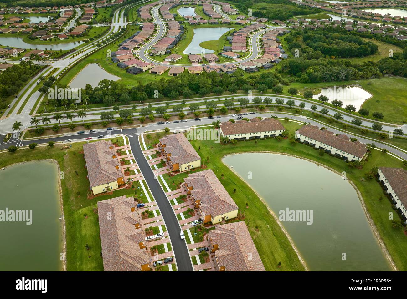 Aerial view of tightly located family houses with retention ponds to ...