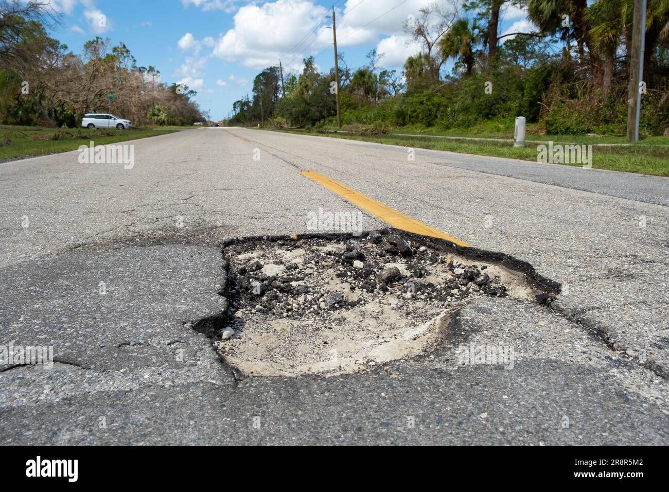 Damaged american road surface with deep pothole. Ruined street in ...
