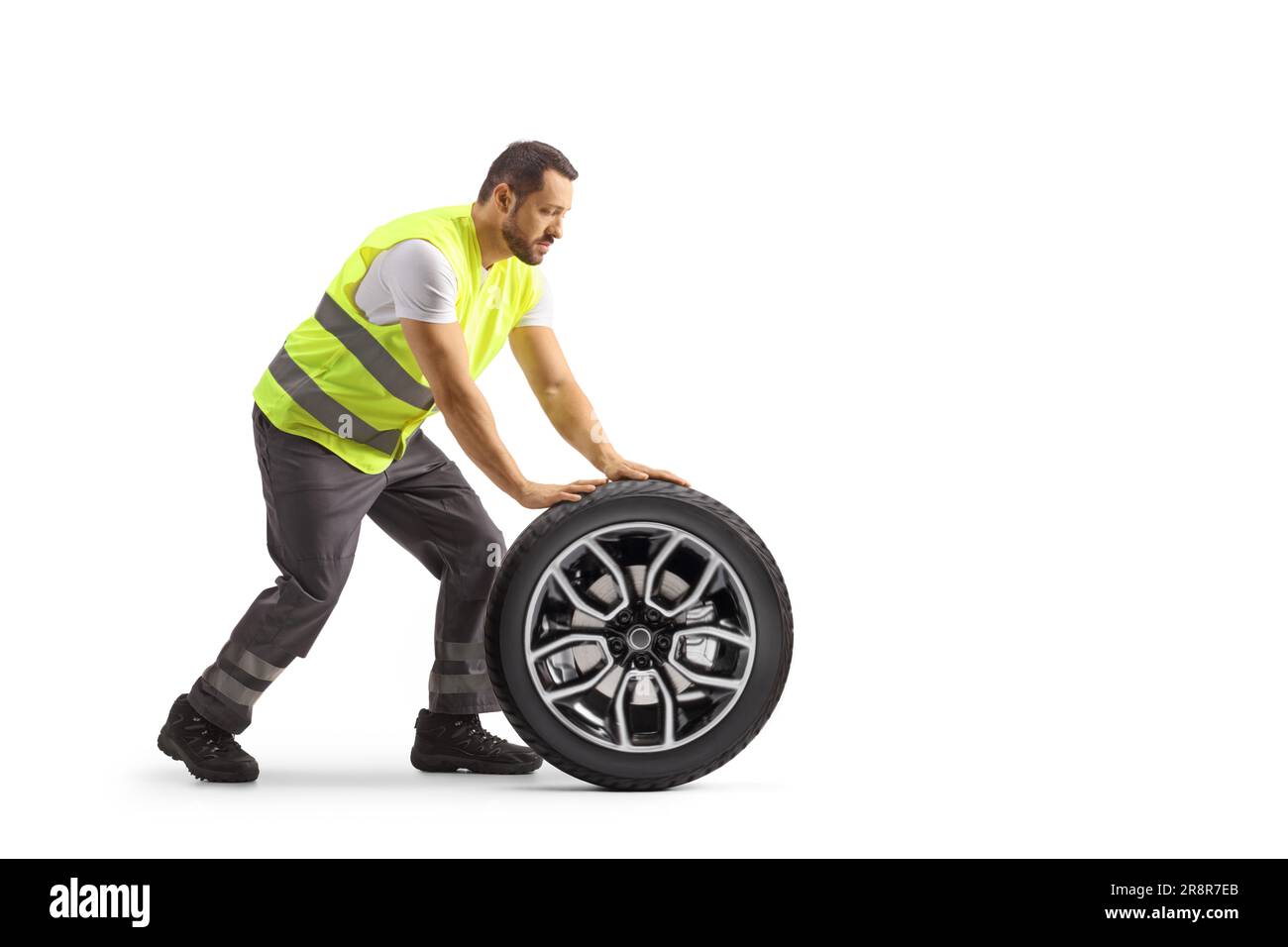 Road assistance mechanic pushing a vehicle tire isolated on white ...