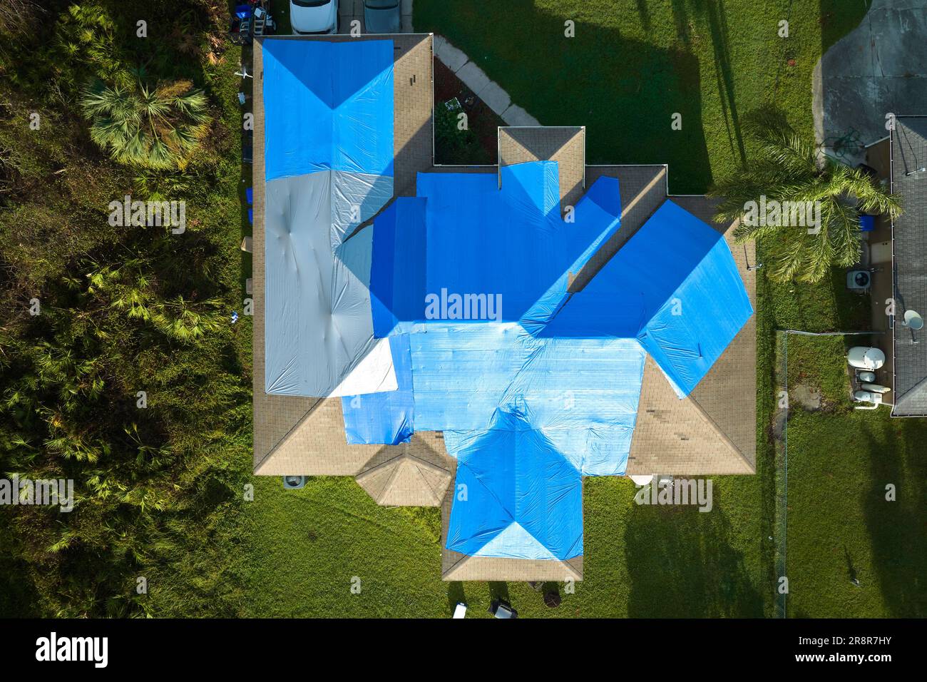 Top view of leaking house roof covered with protective tarp sheets ...