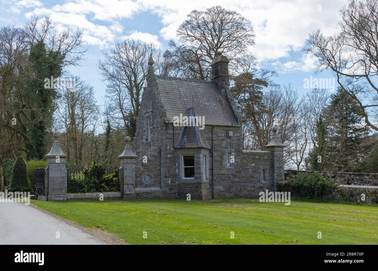 Grey stone old building with a bay window and greystone fence posts ...