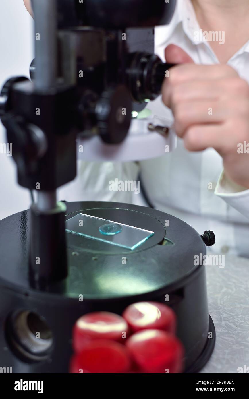 hands with microscope examining samples and liquid Stock Photo - Alamy