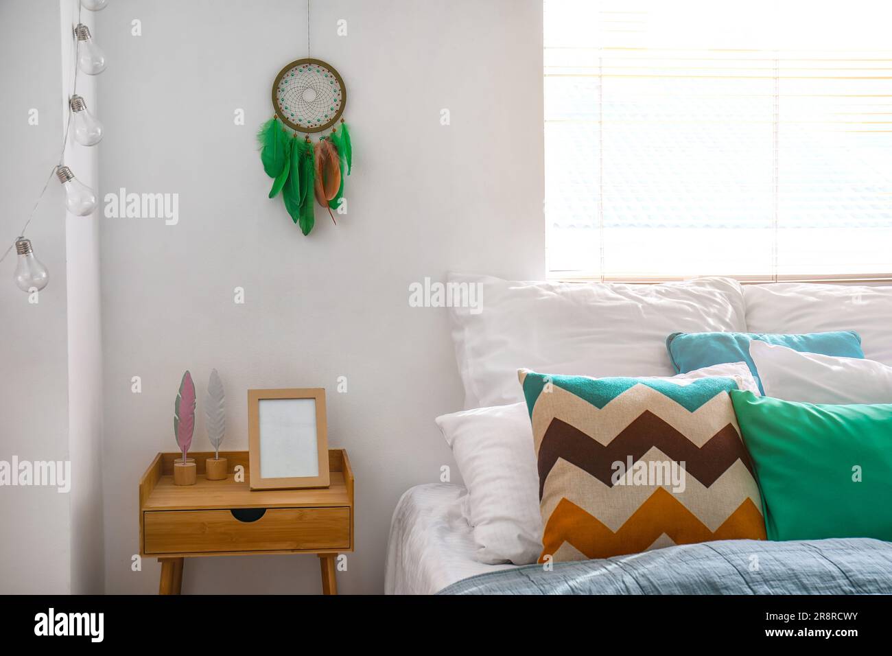 Interior of modern bedroom with bed, bedside table and dream catcher ...