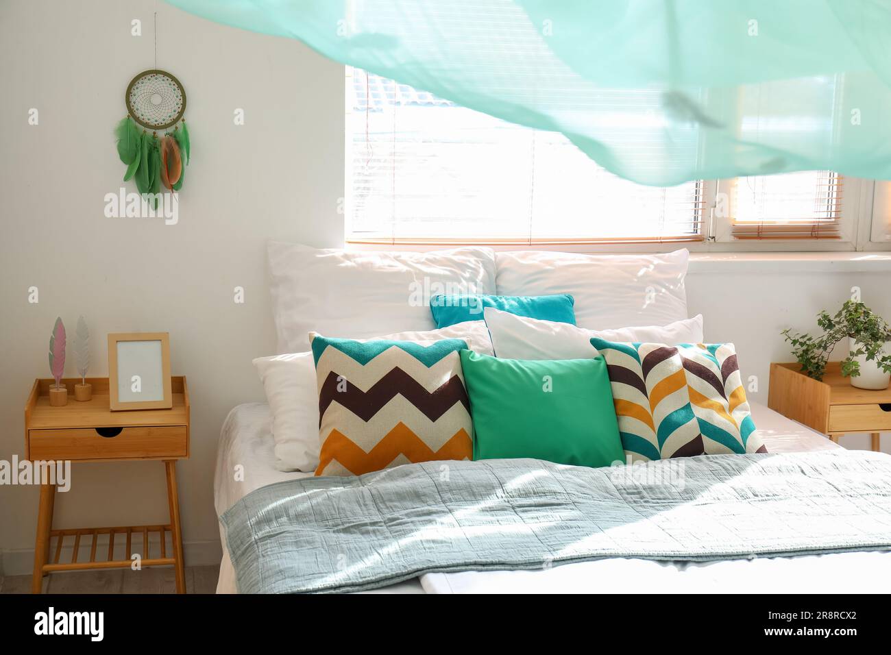 Interior of modern bedroom with bed, bedside table and dream catcher ...