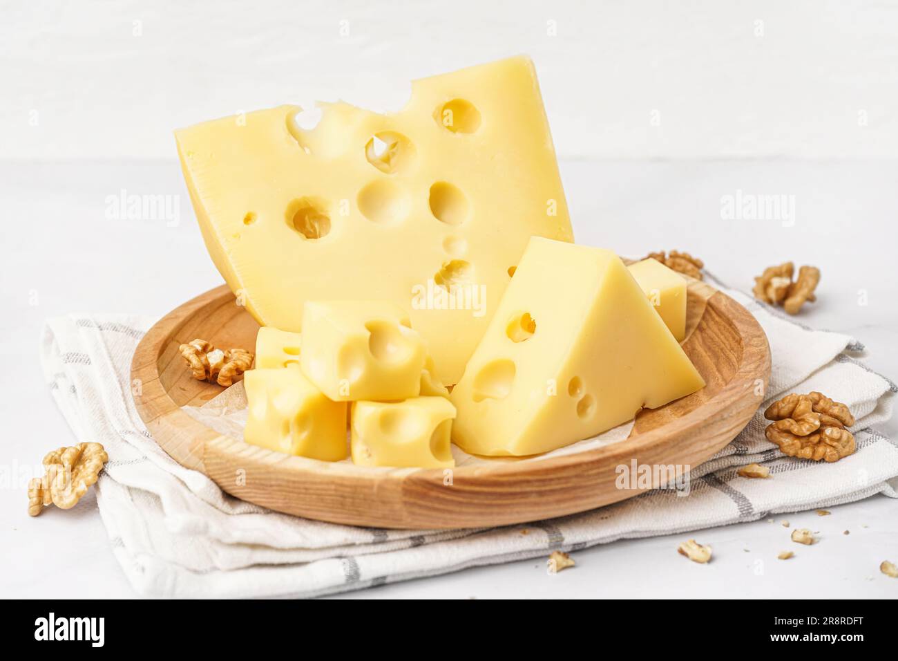 Plate with pieces of Swiss cheese and walnut on white background Stock ...