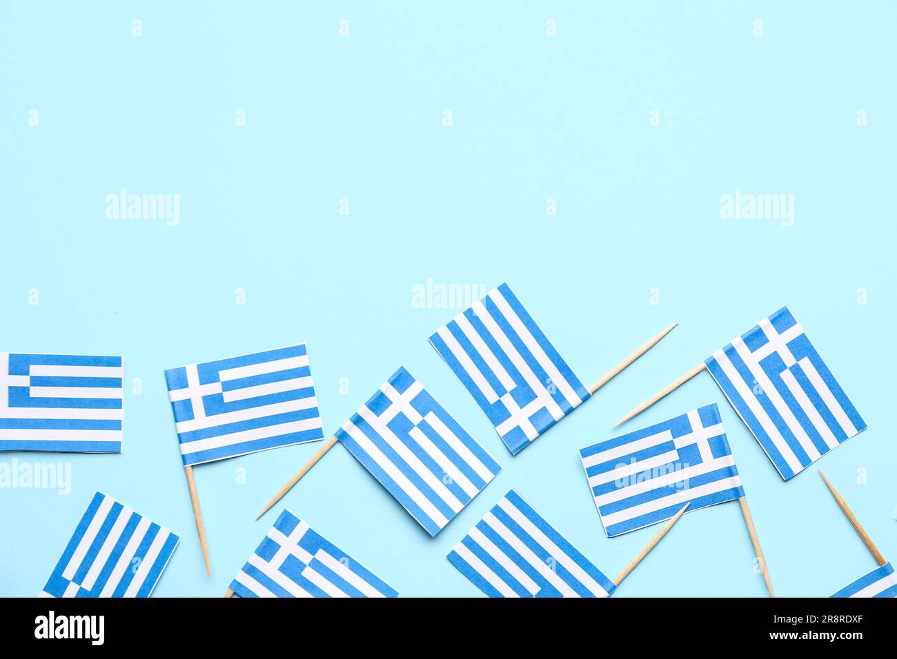 Many paper flags of Greece on blue background Stock Photo - Alamy