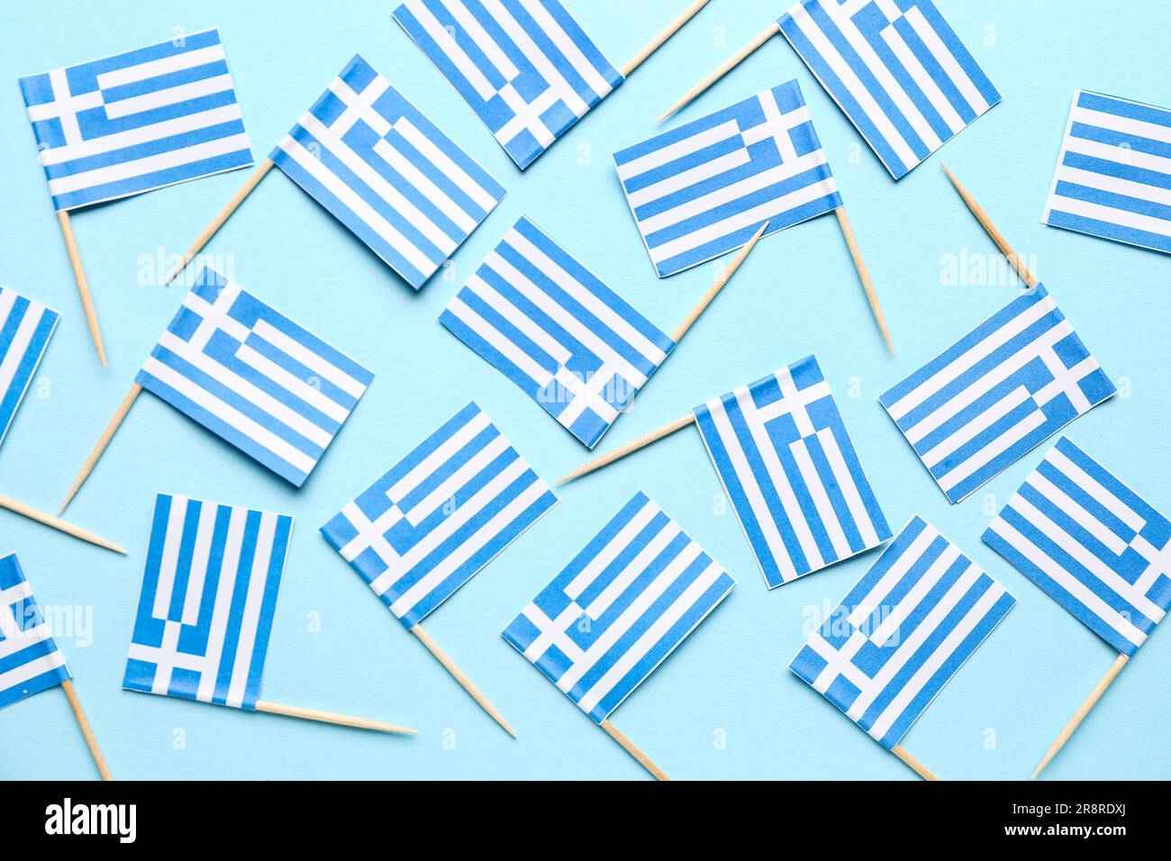 Many paper flags of Greece on blue background Stock Photo - Alamy