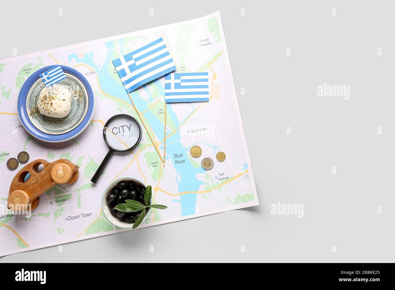 Flags of Greece, city map, wooden car and euro coins on grey background ...