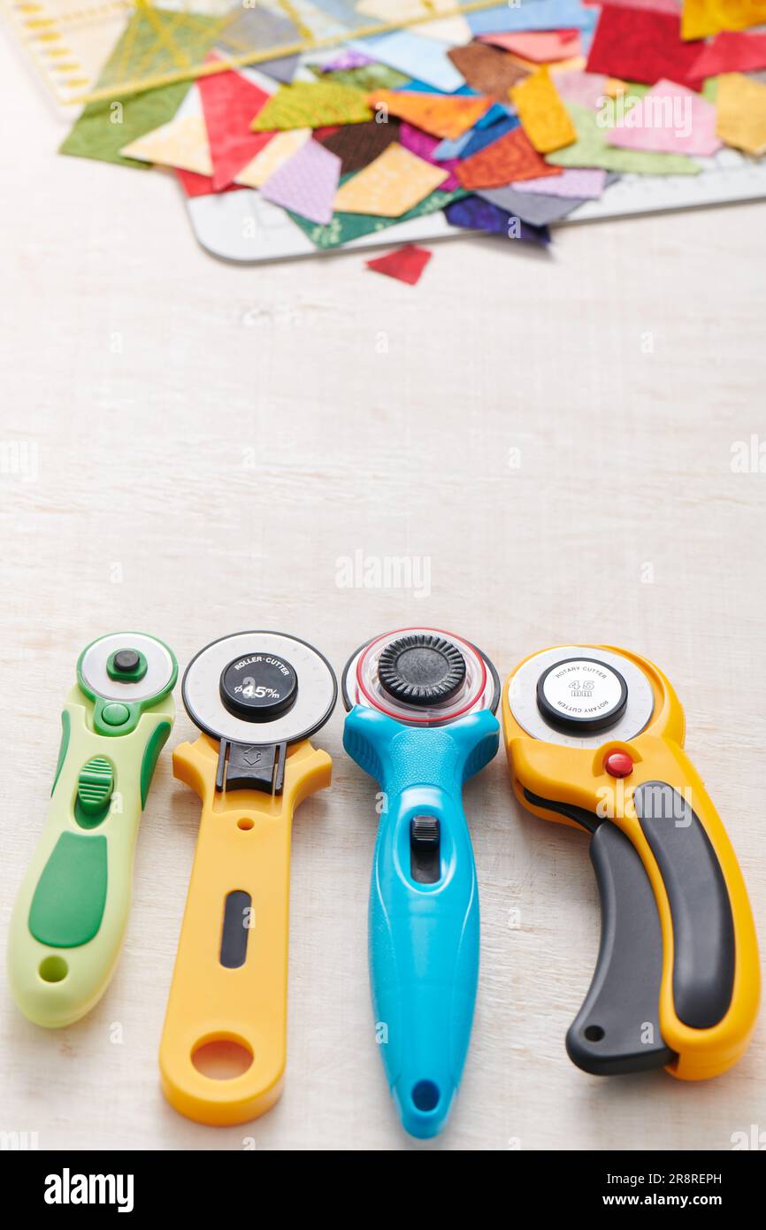 Four roller cutter, fabric waste on craft mat, text space at center ...