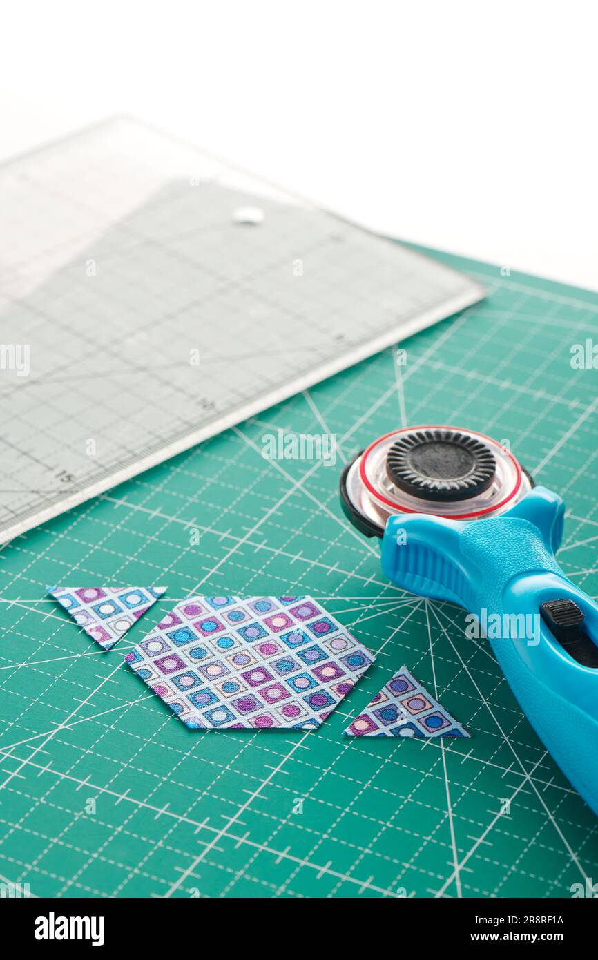 The process of cutting pieces of fabric in the shape of hexagons to ...
