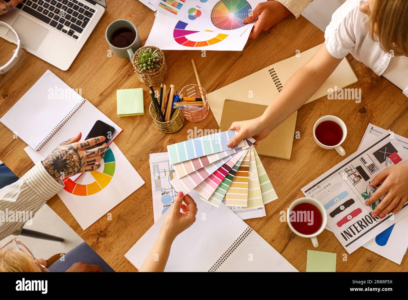 Team of graphic designers working with color palettes at table in ...