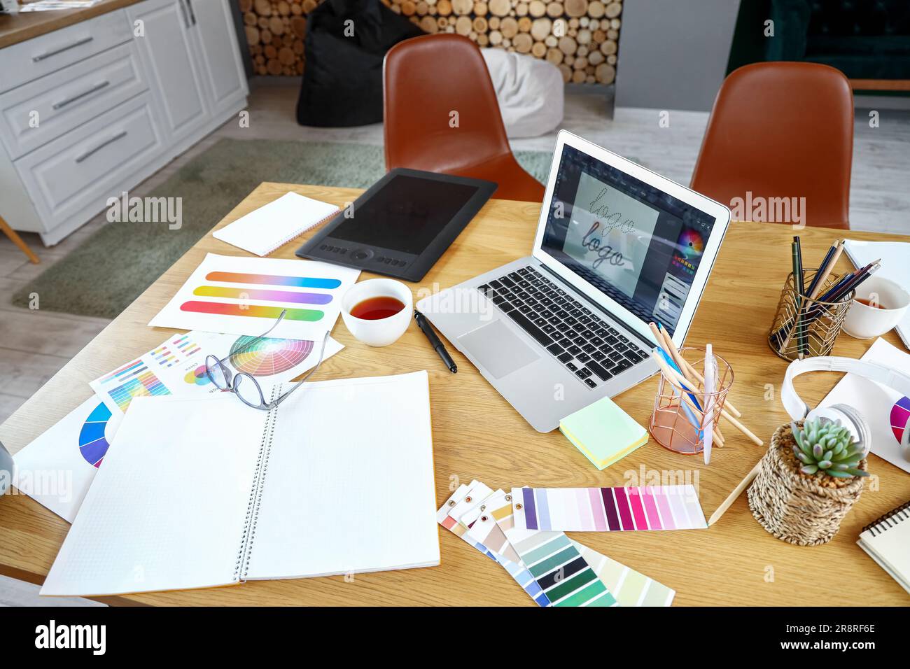 Graphic designer's workplace with laptop and color palettes in office ...