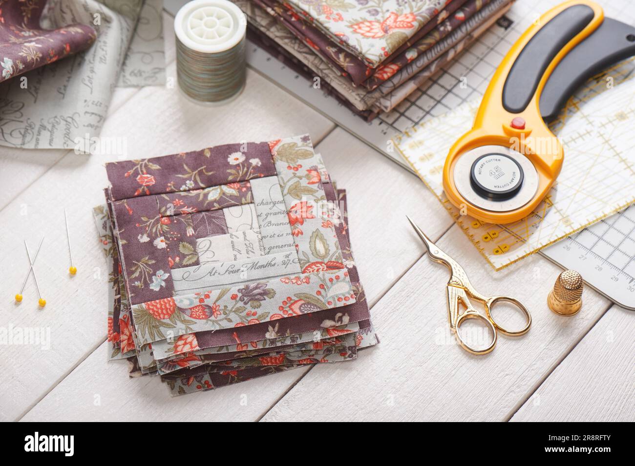 Patchwork log cabin blocks, stack of blocks, sewing accessories on ...