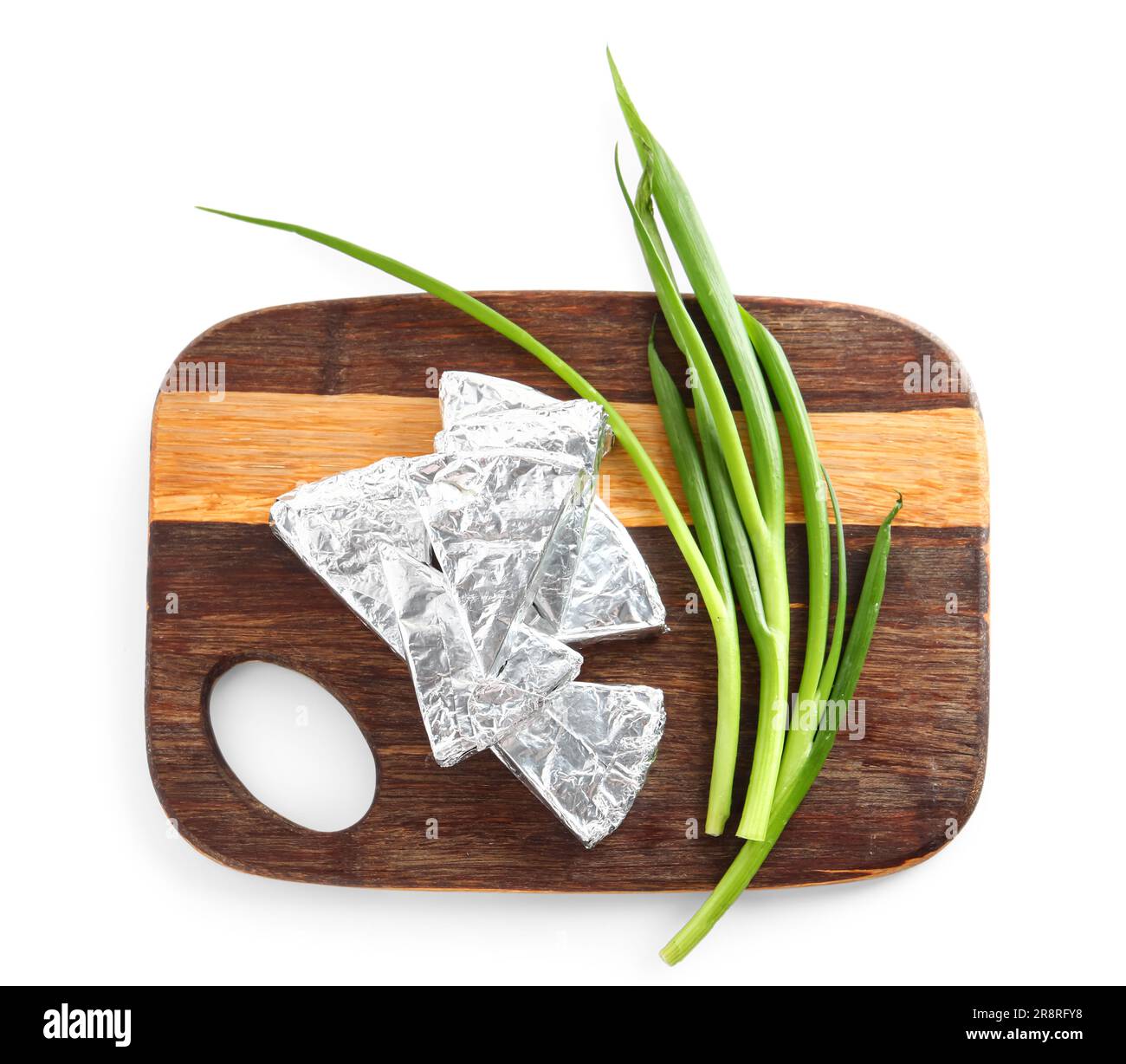 Board with triangles of tasty processed cheese in foil and onion on ...