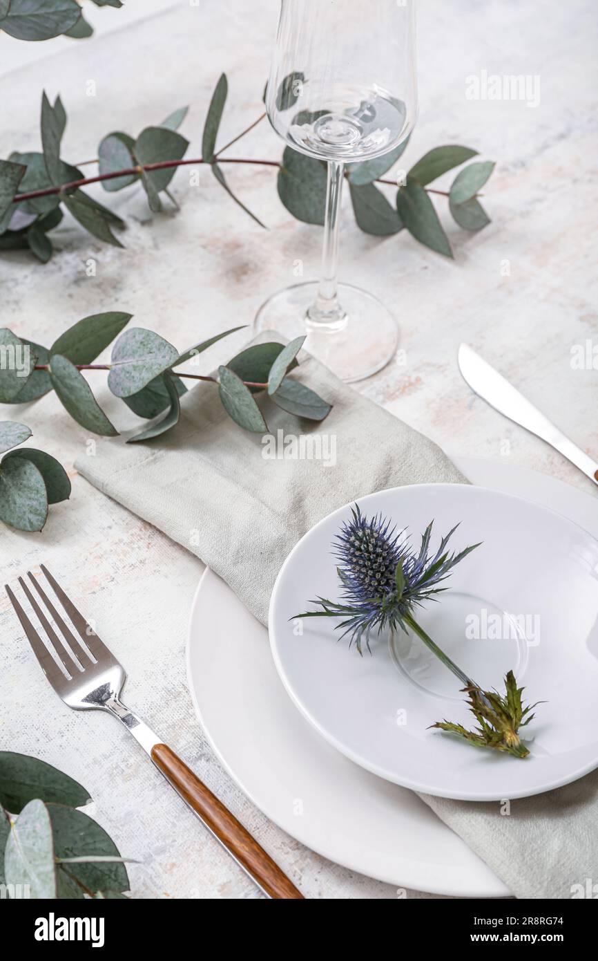 Beautiful table setting with eryngium flower and eucalyptus branches on ...