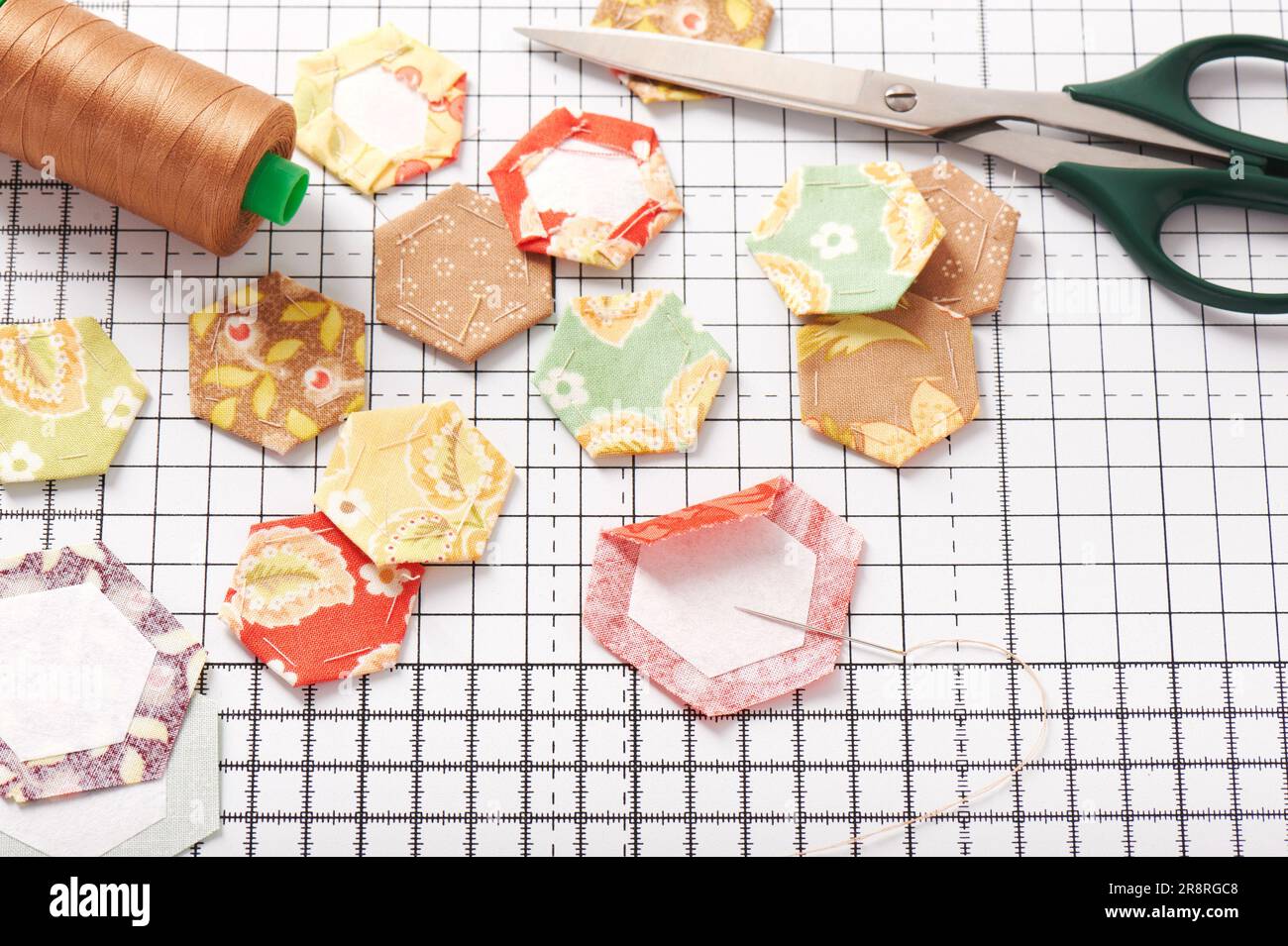 English paper pieced hexagons on white craft mat Stock Photo - Alamy