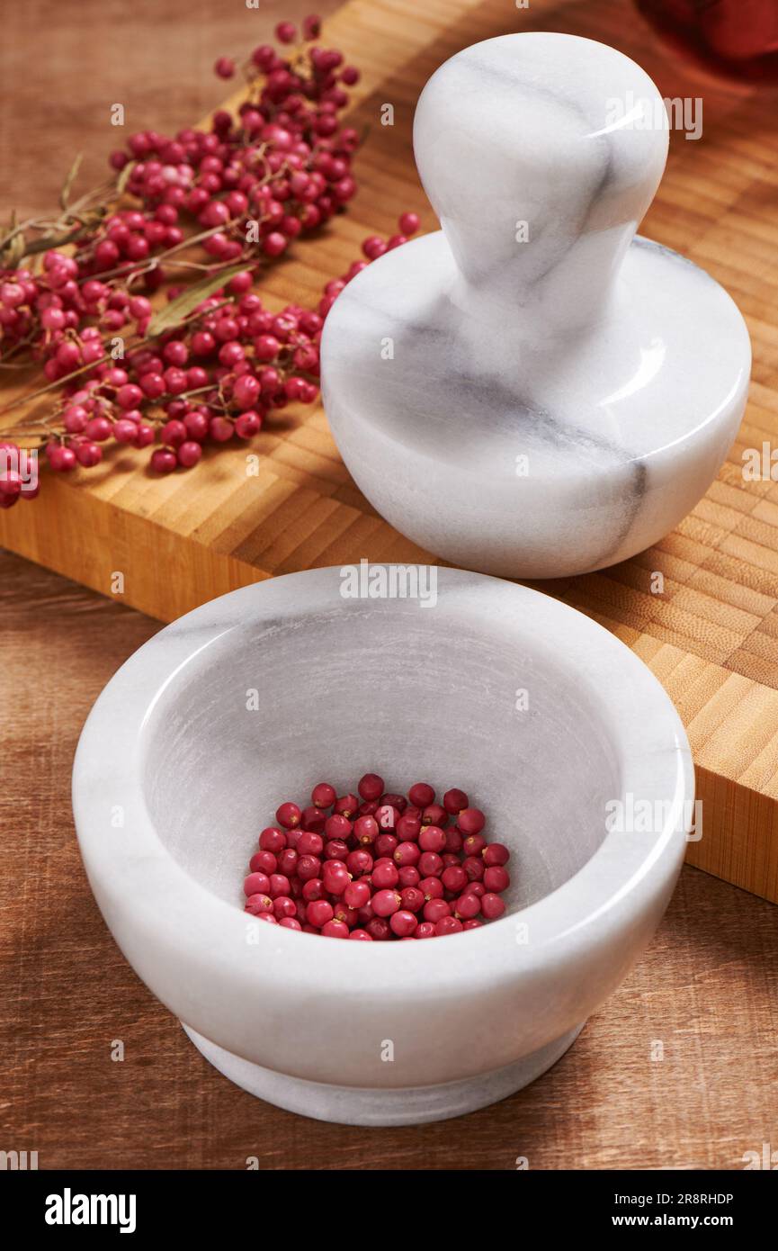 Dry rose pepper in white marble mortar next pestle Stock Photo - Alamy