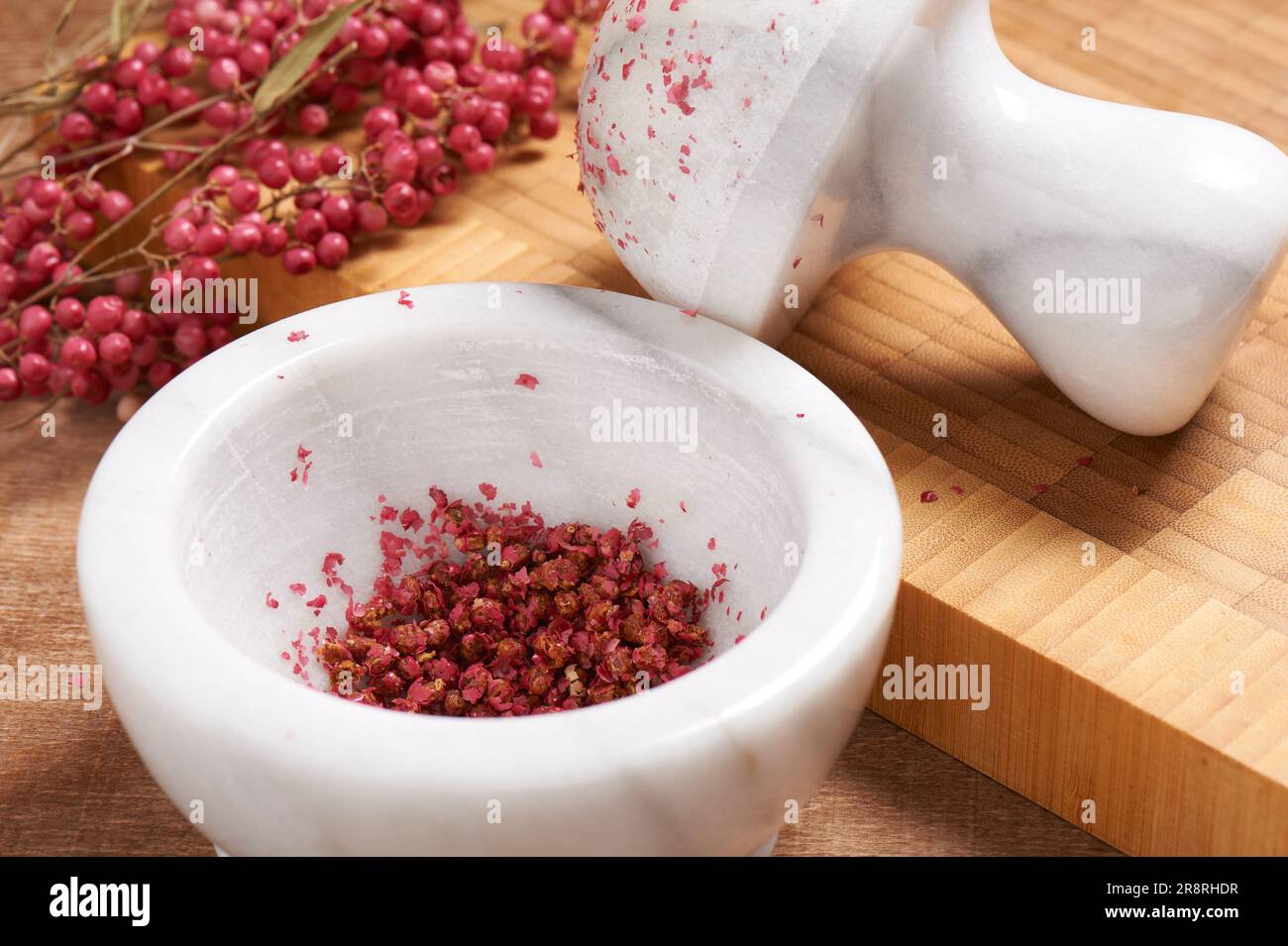 Dry rose pepper in white marble mortar next pestle Stock Photo - Alamy