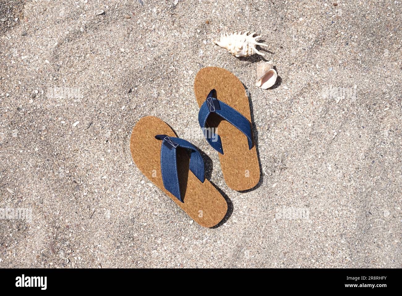 Flip-flops with shells on sand beach background Stock Photo - Alamy
