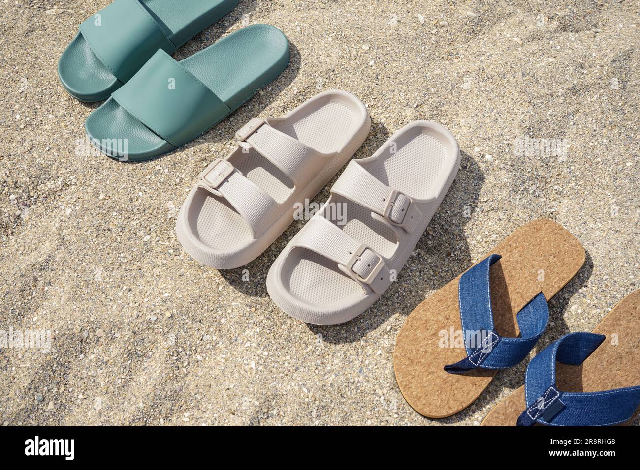 Different flip-flops on sand beach background Stock Photo - Alamy
