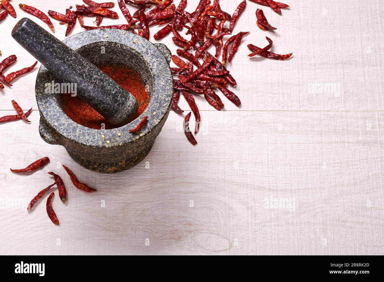 Pestle with mortar, surrounded by dried chili peppers. Cooking spices ...