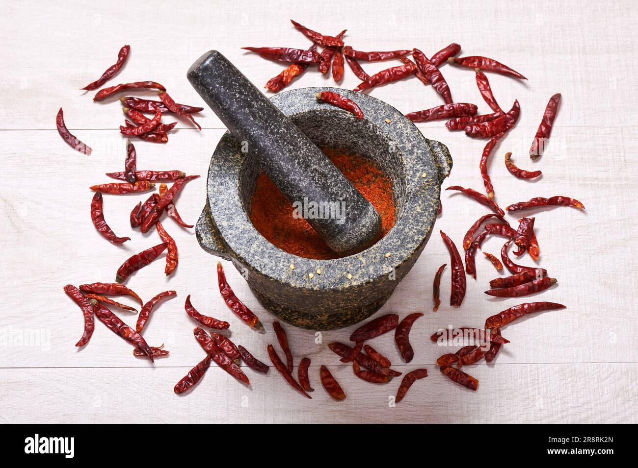 Pestle with mortar, surrounded by dried chili peppers. Cooking spices ...
