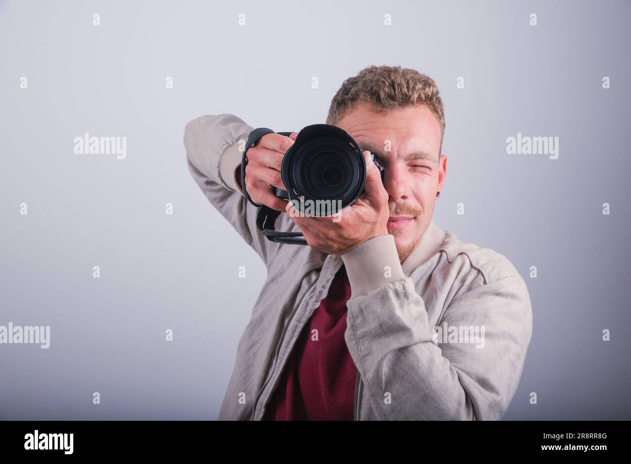 A photographer takes a photograph with his DSLR, studio shot with a ...