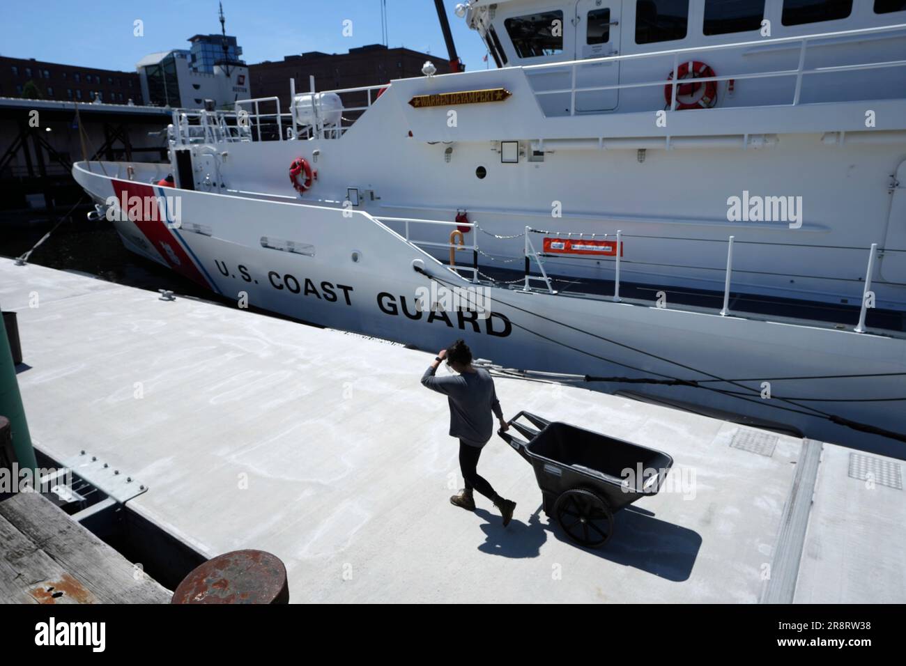 A person pulls a cart past the U.S. Coast Guard Cutter Warren Deyampert ...