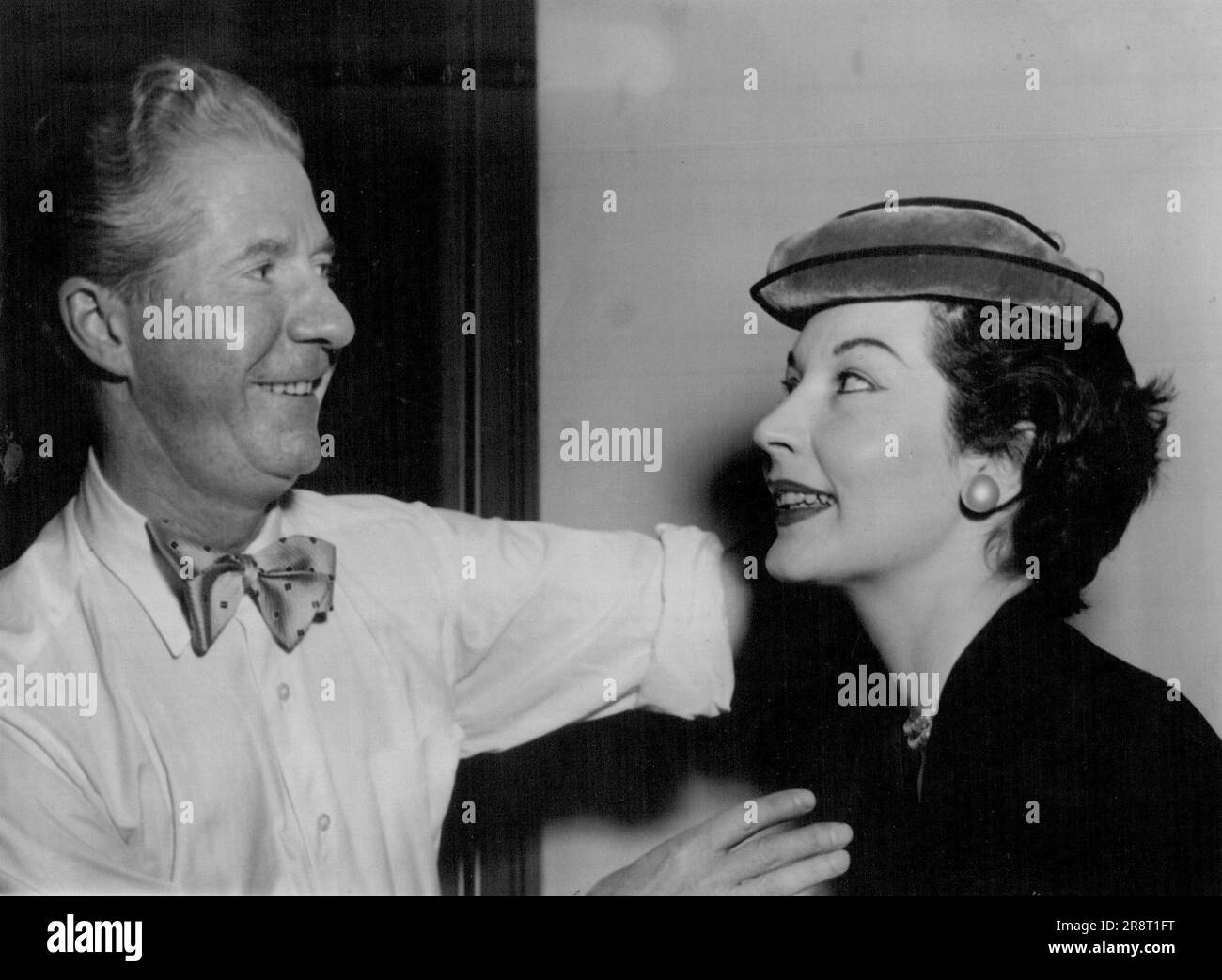 Royal milliner Aage Thaarup adjusts one of his hats worn by model ...