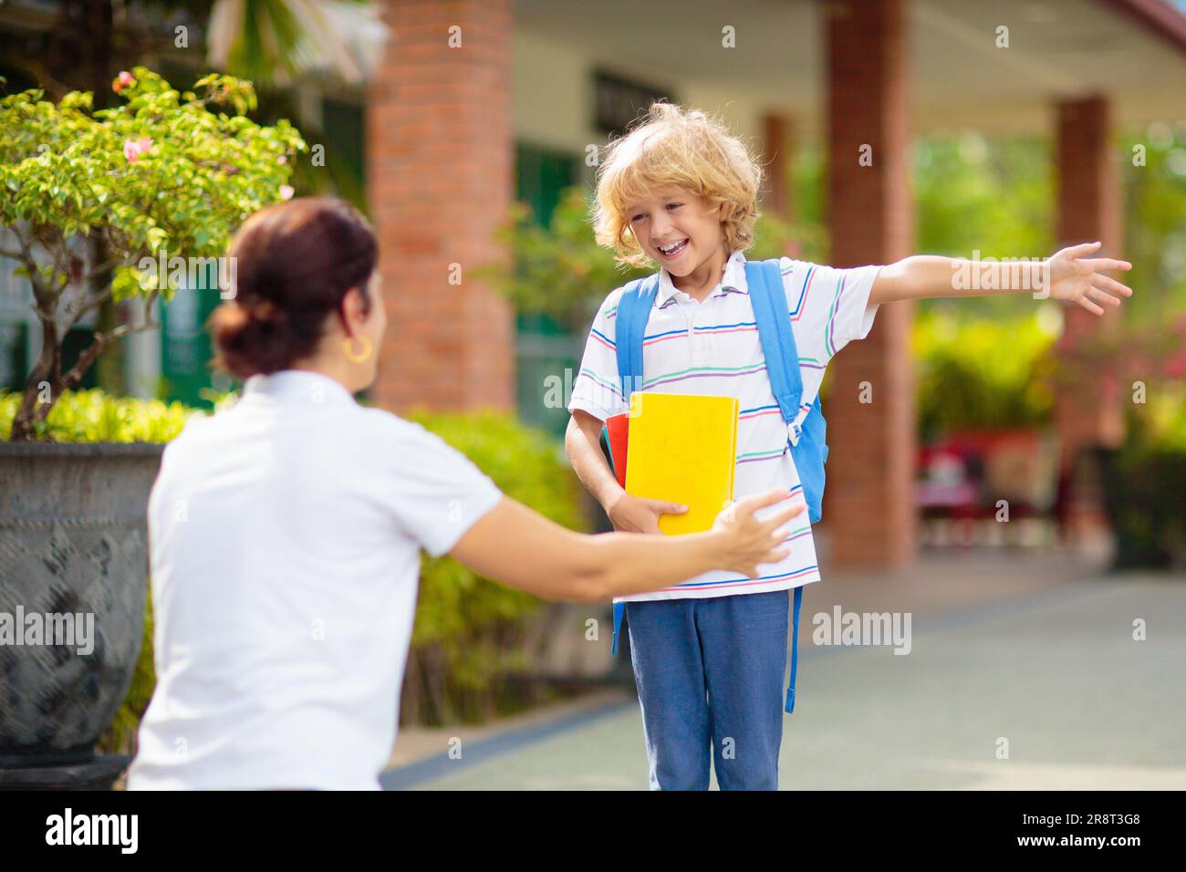 Mother bringing child to school. Parents pick up little boy after class. Young mom picking up ...