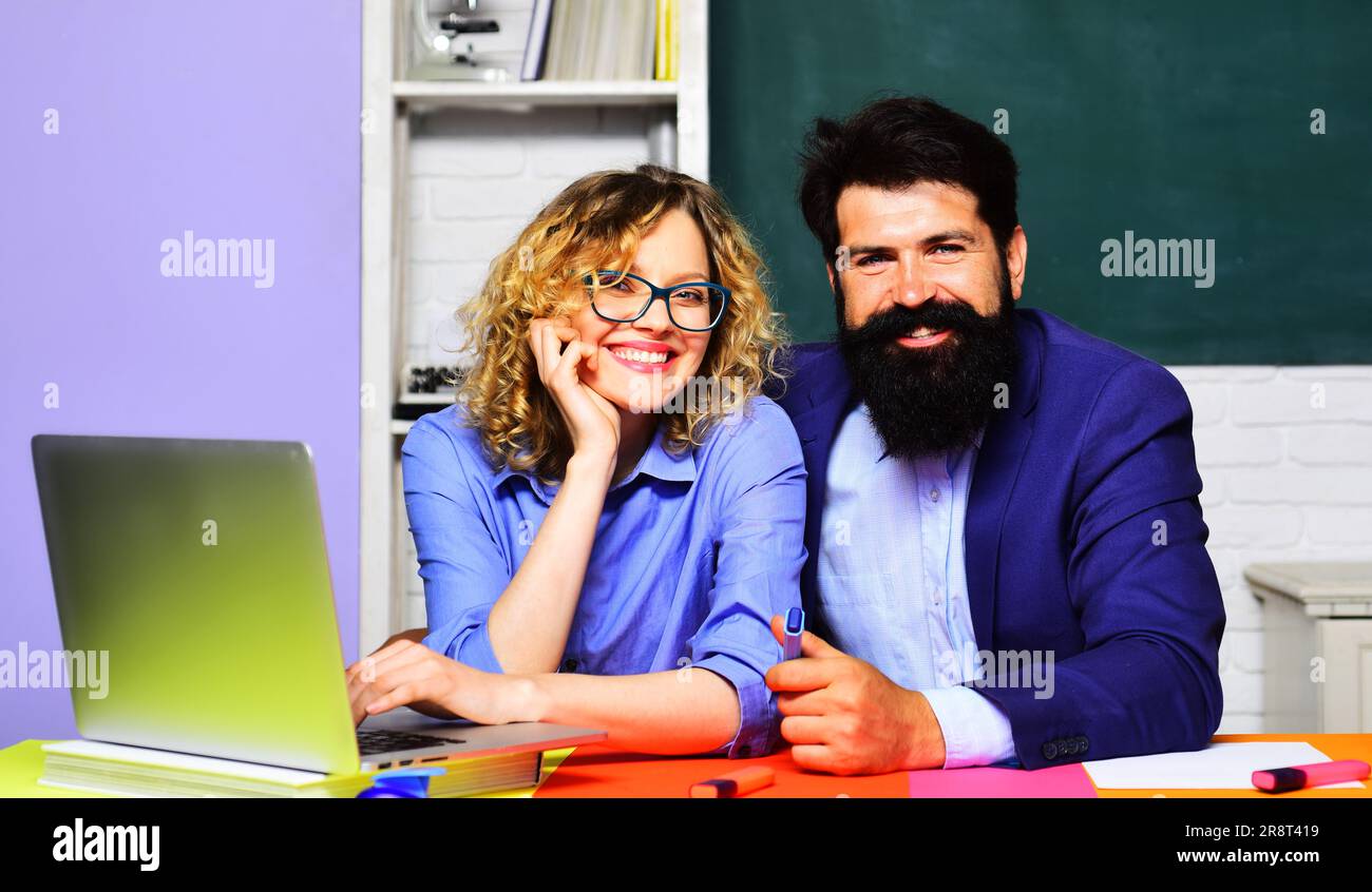 Two male and female students in classroom with laptop. Cooperation ...