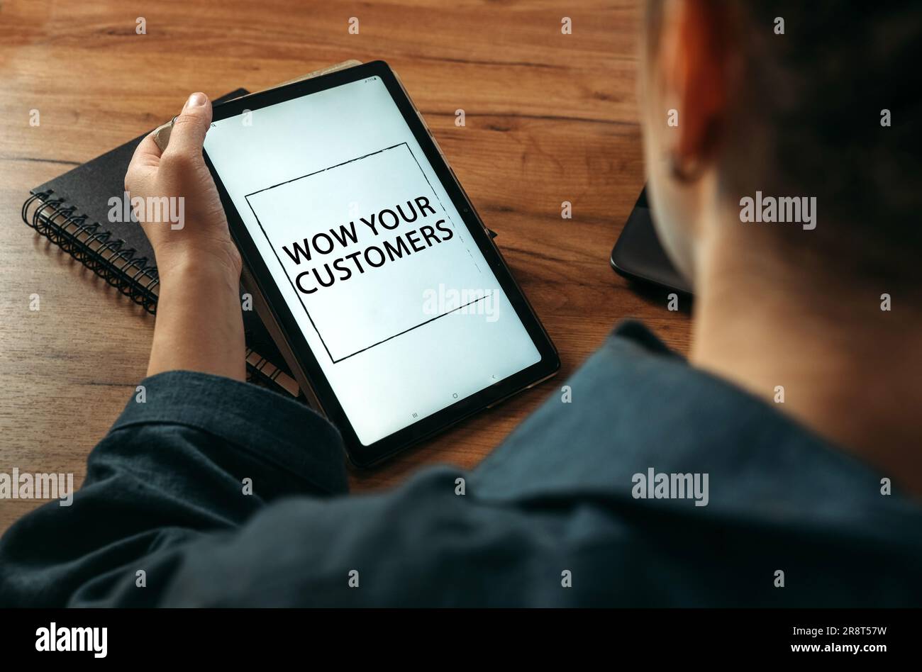 Business concept. A woman holds a tablet in her hands on the screen of ...
