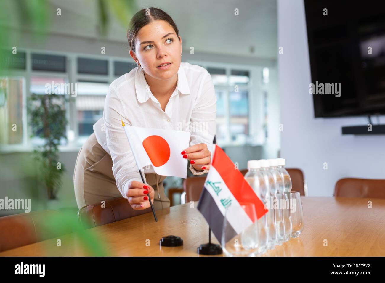 Young lady sets miniatures flags of Iraq and Japan for international ...