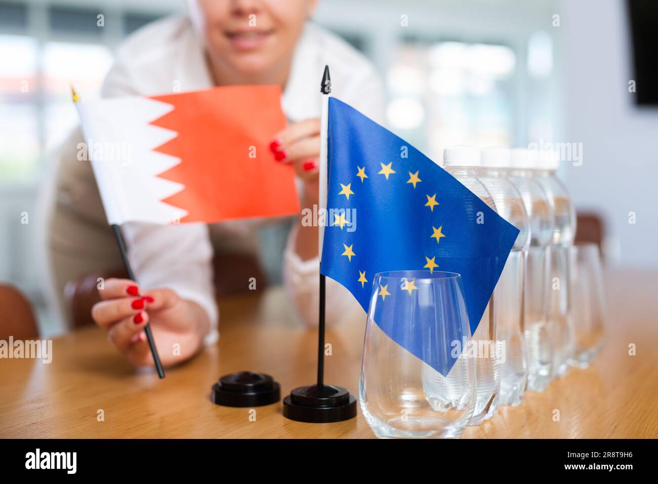 Female secretary places flags of Bahrain and European Union flag on the ...