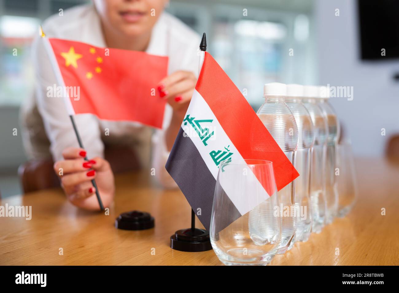 Employee of delegation prepares negotiating table - sets up flag of ...