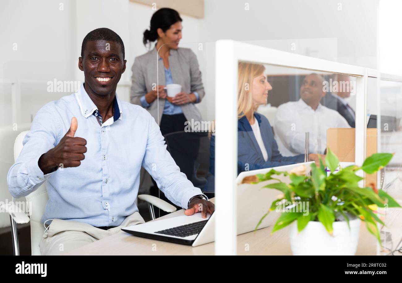 Cheerful African American businessman at workplace in coworking space ...