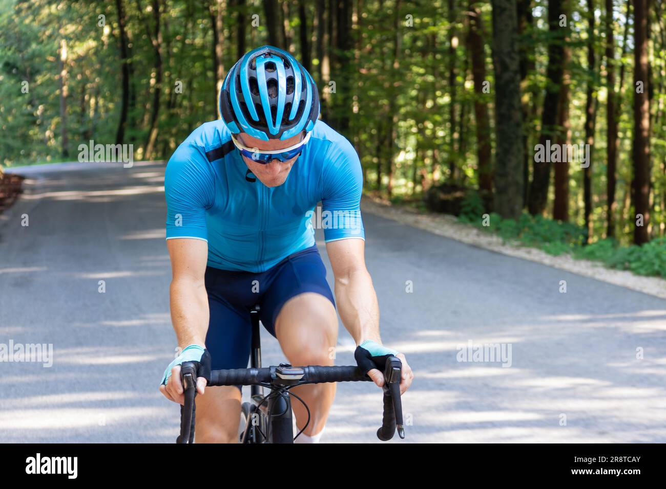 Male road racing cyclist in a blue sports jersey, with helmet and ...