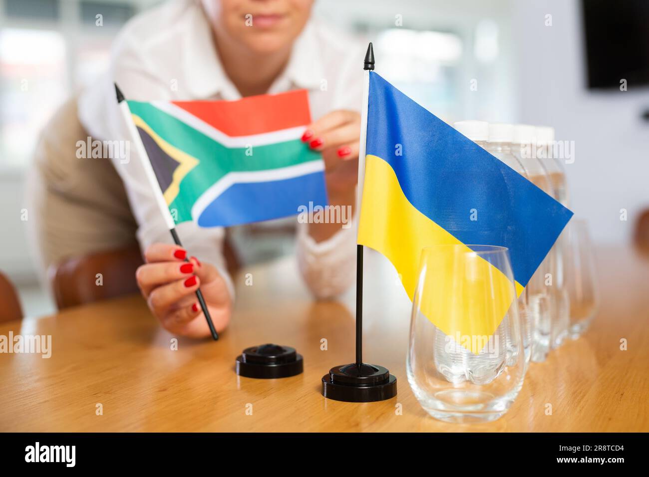 Unrecognizable girl sets midget flags of Ukraine and South Africa ...