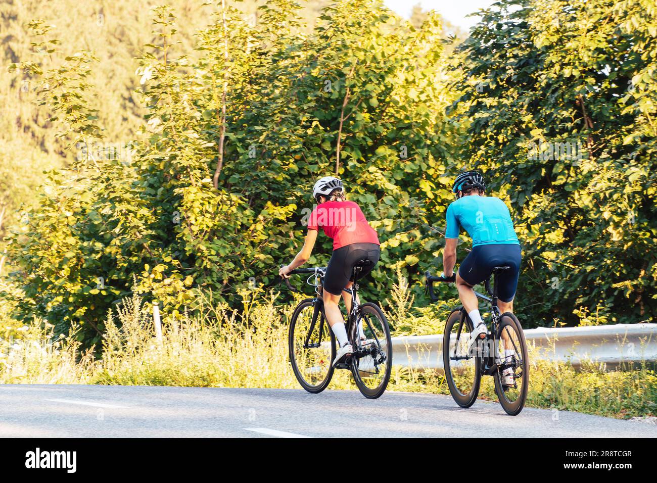 Two professional athlete cyclists, a woman, and a man, riding a stage ...