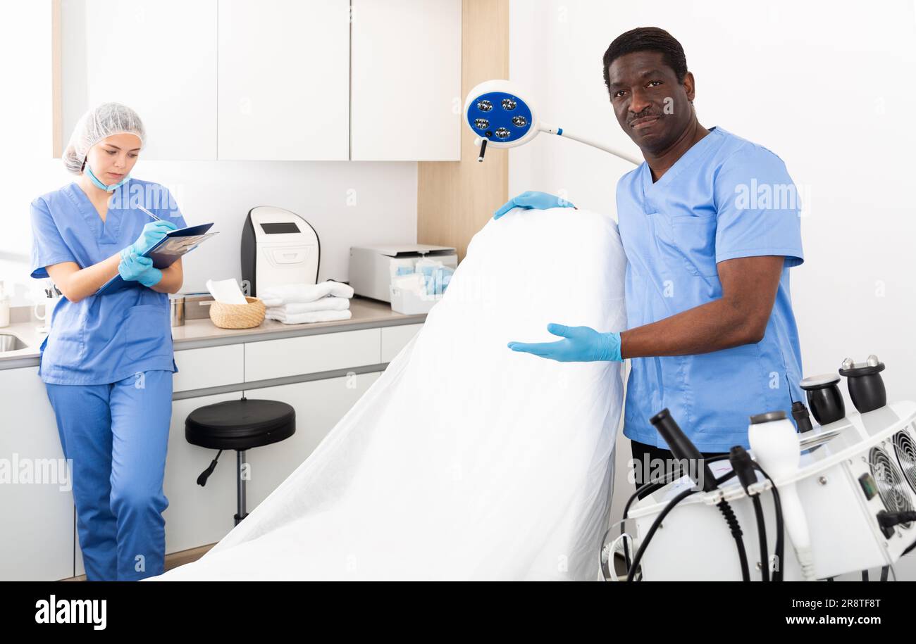 Two professional cosmetologists man and woman welcoming patient Stock ...