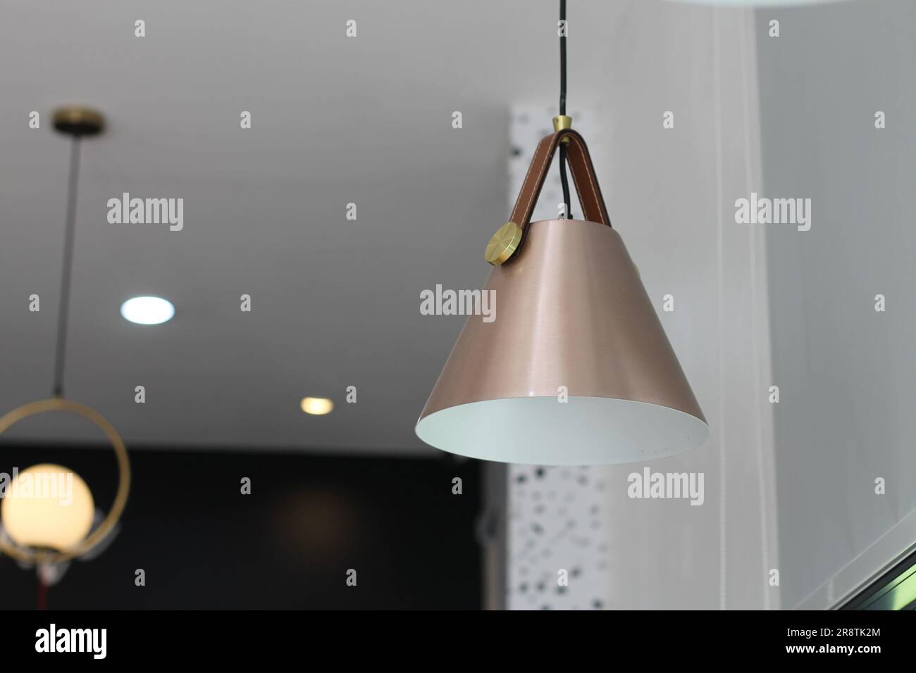 A cream-colored cone lamp hangs from the ceiling to provide light Stock ...