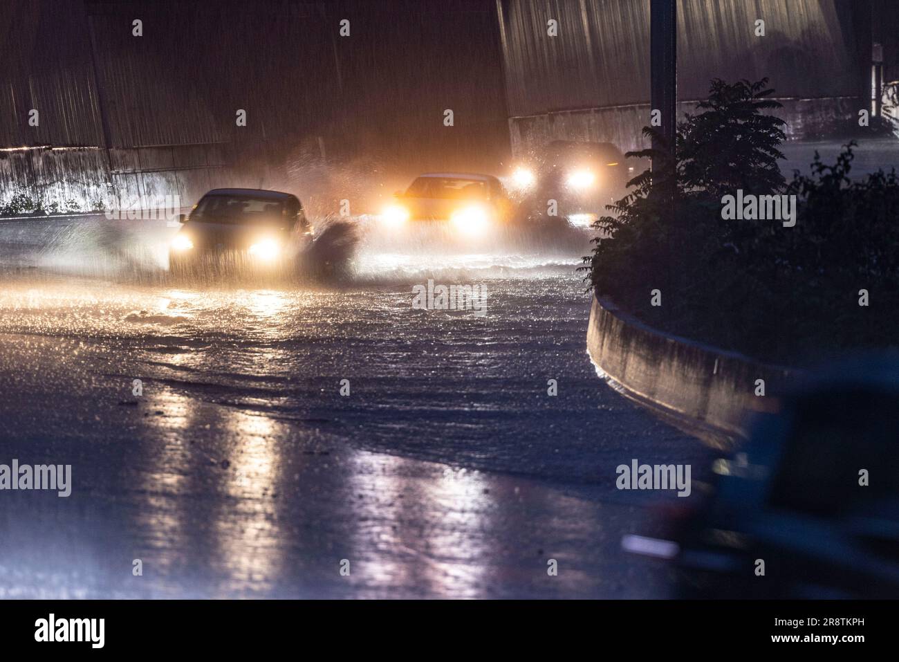Vehicles drive through a flooded section of the A59 highway as heavy ...