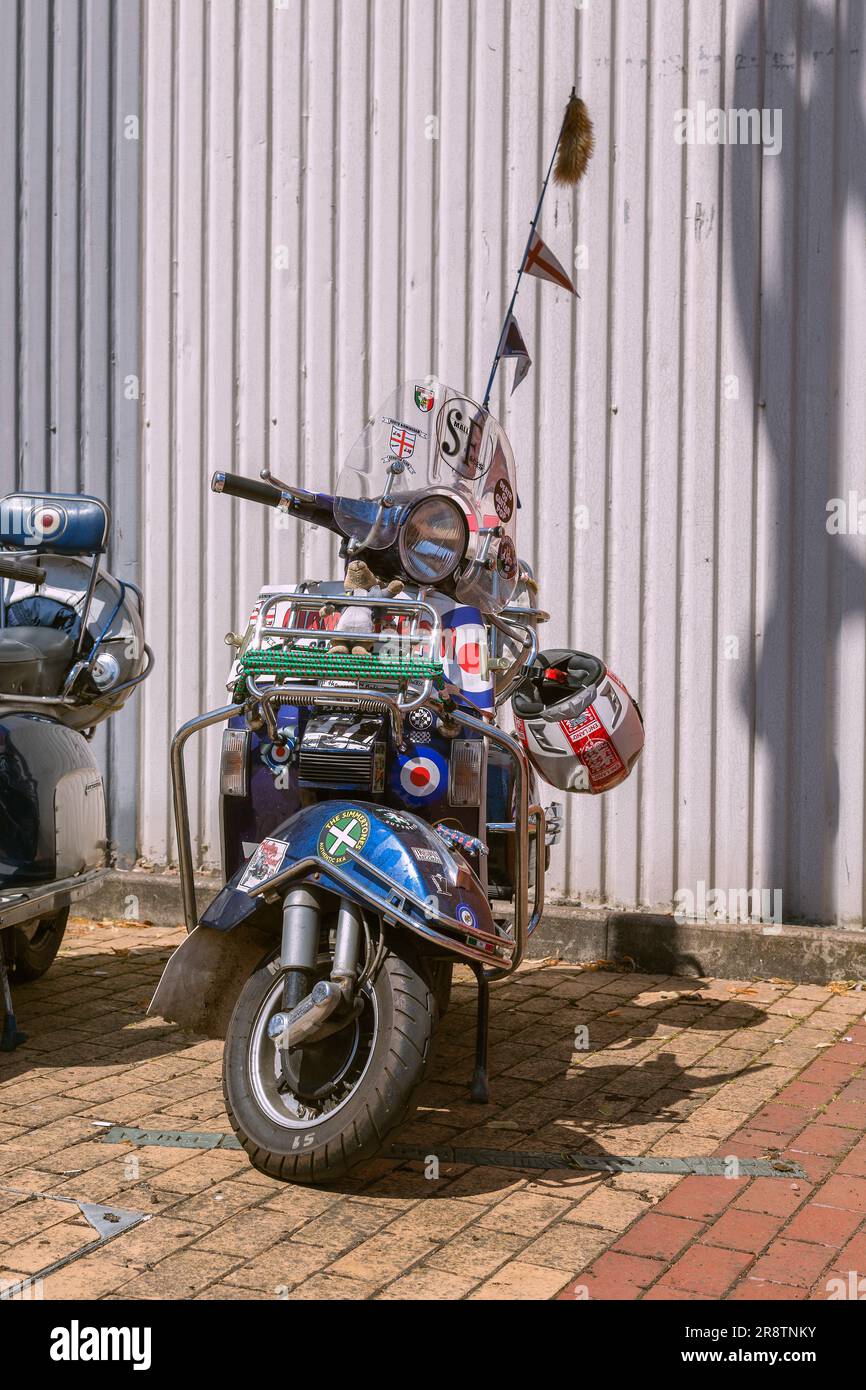 A Piaggio motor scooter parked in the street. The scooter has been ...