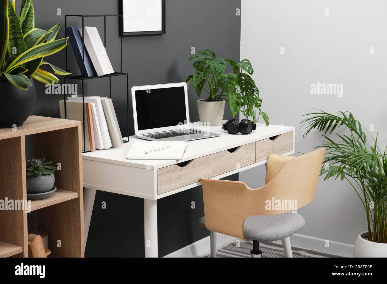 Workplace with laptop, stationery on desk and chair in home office ...