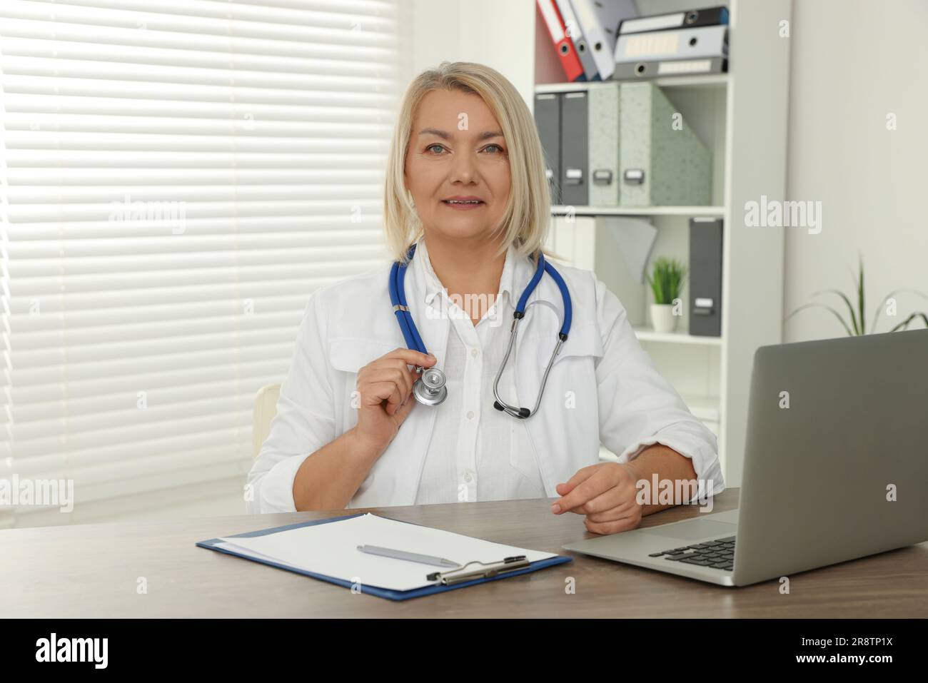 Doctor sitting wooden table hi-res stock photography and images - Alamy