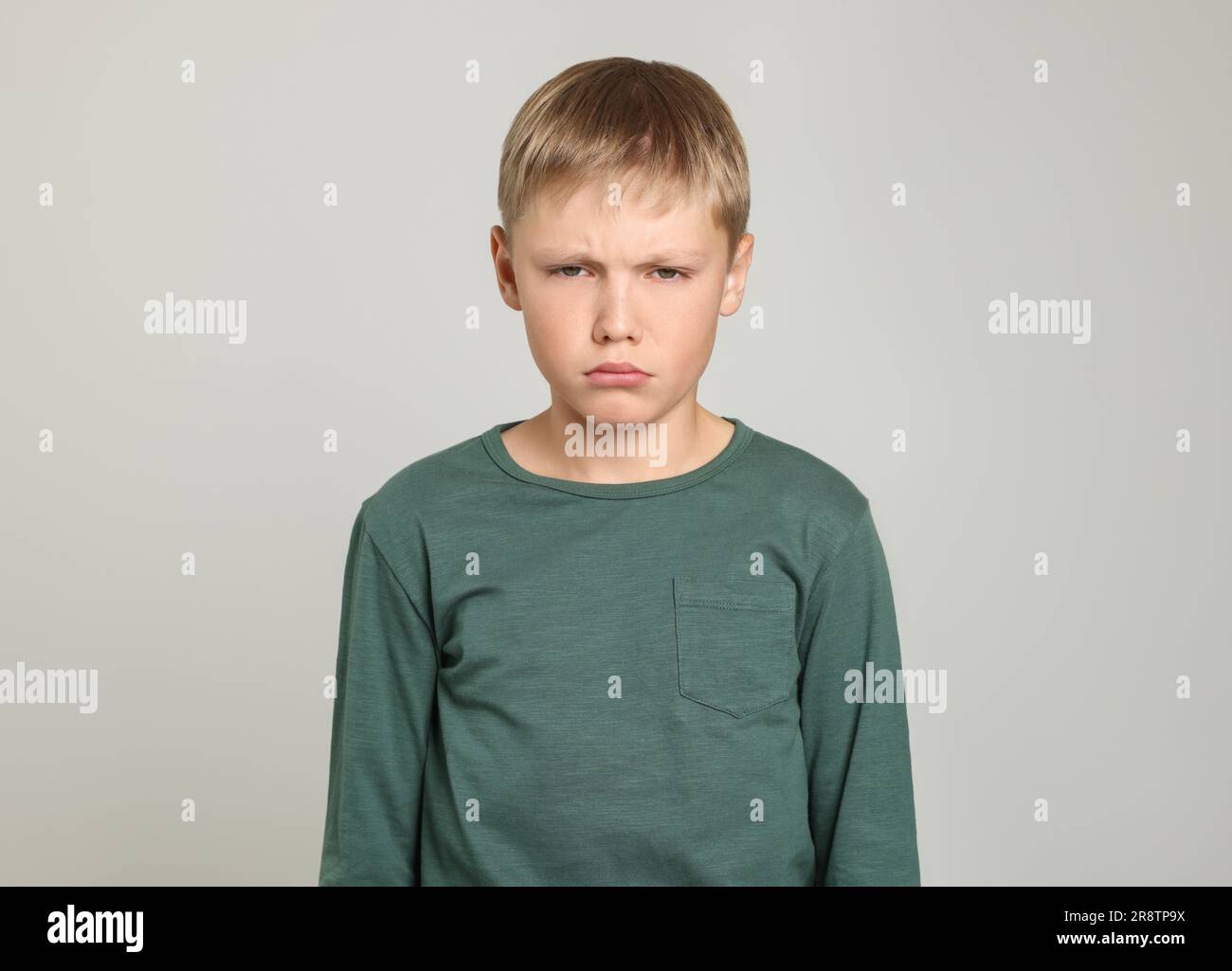 Upset boy on light grey background. Children's bullying Stock Photo - Alamy