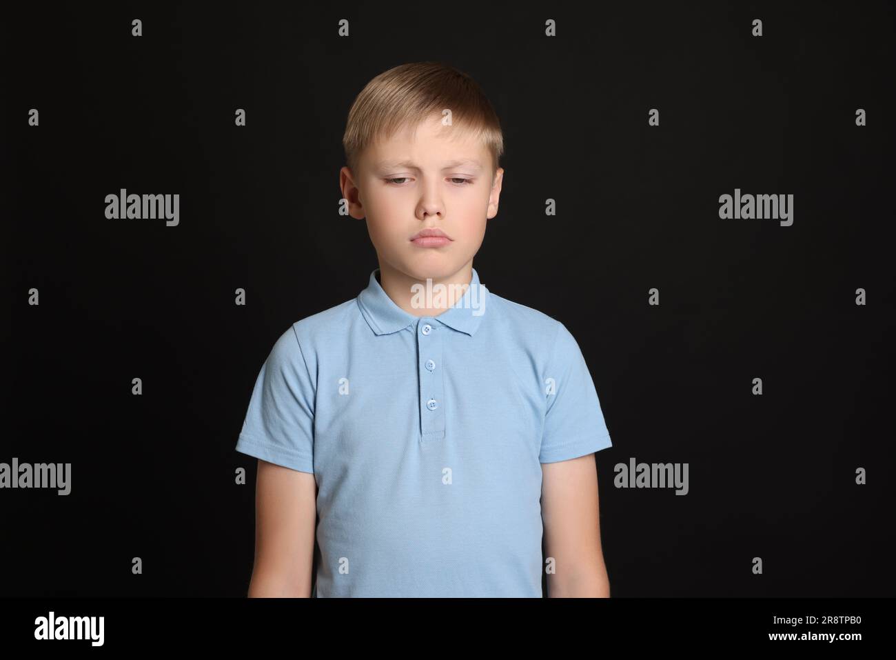 Upset boy on black background. Children's bullying Stock Photo - Alamy
