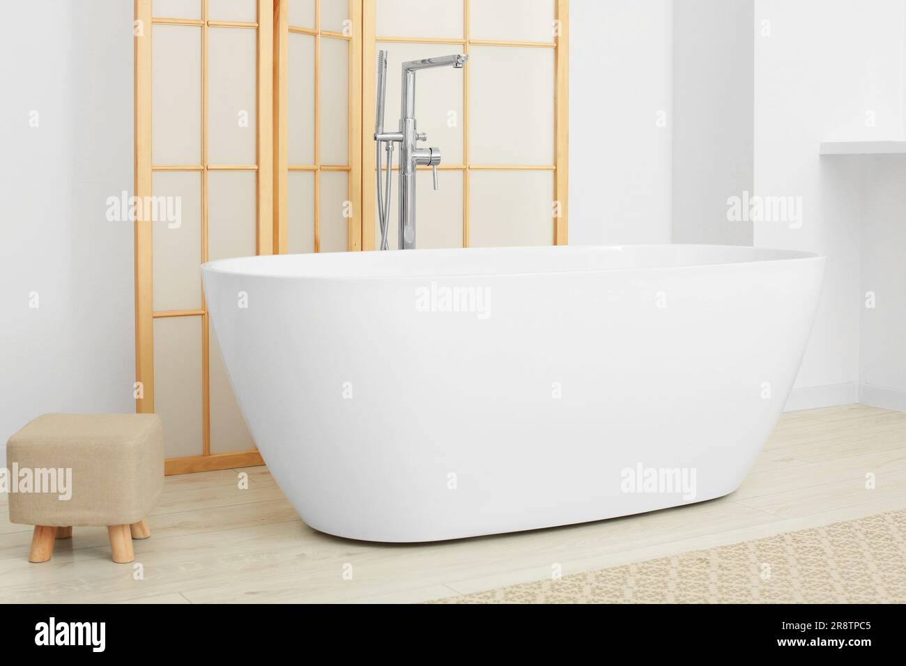 Beautiful white tub and ottoman in bathroom. Interior design Stock Photo - Alamy