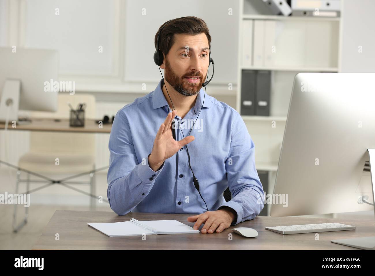Hotline operator with headset working in office Stock Photo - Alamy