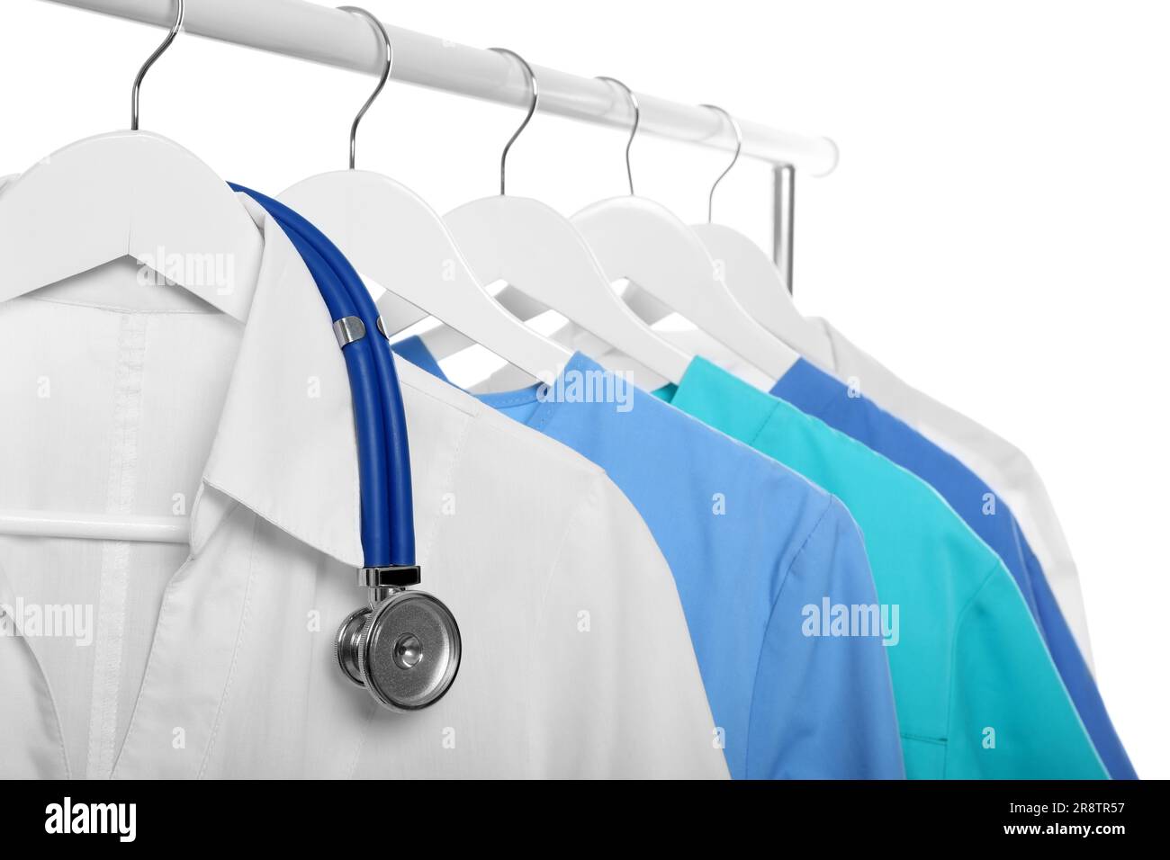 Doctor's gown with stethoscope and different medical uniforms on rack ...